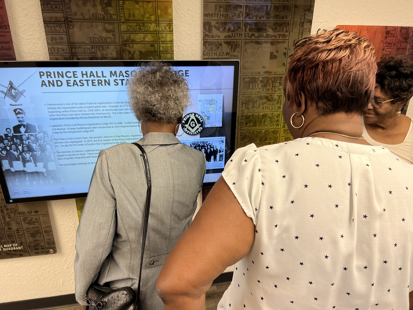 Coleman Bush History Women looking at touochscreen - LkldNow